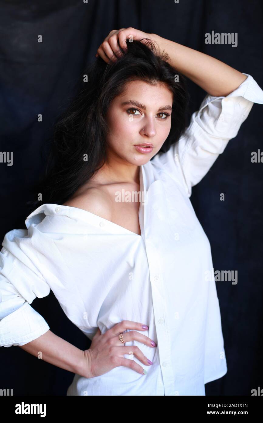 Confident in her beauty. Side view of beautiful young woman in simple ...