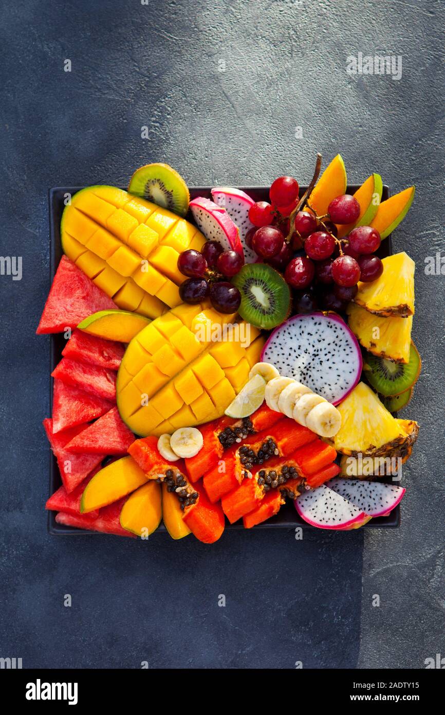Tropical fruits assortment on a plate. Slate background. Copy space ...