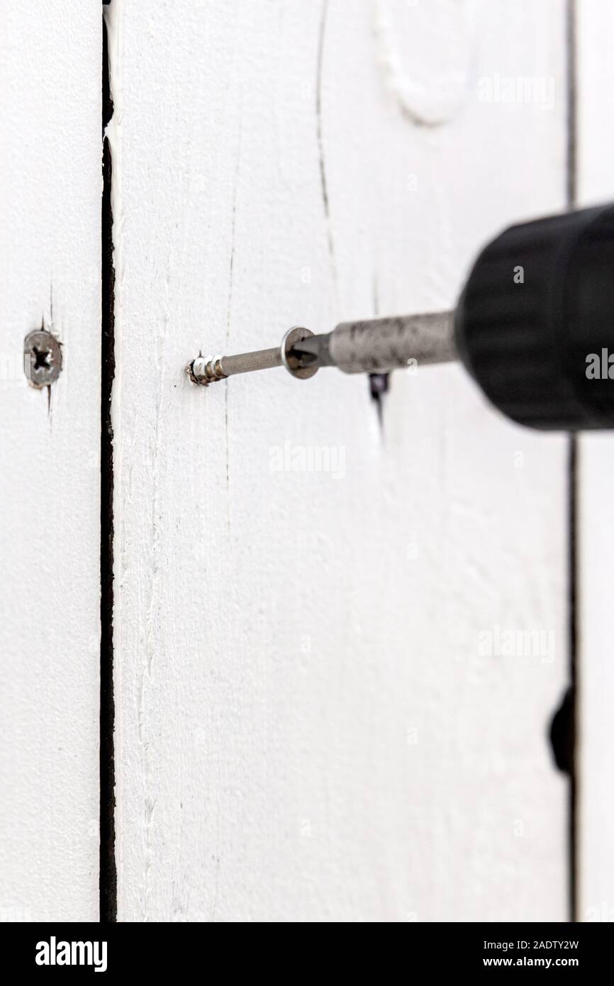 A chipboard screw is screwed into a board, wooden board is fixed with ...