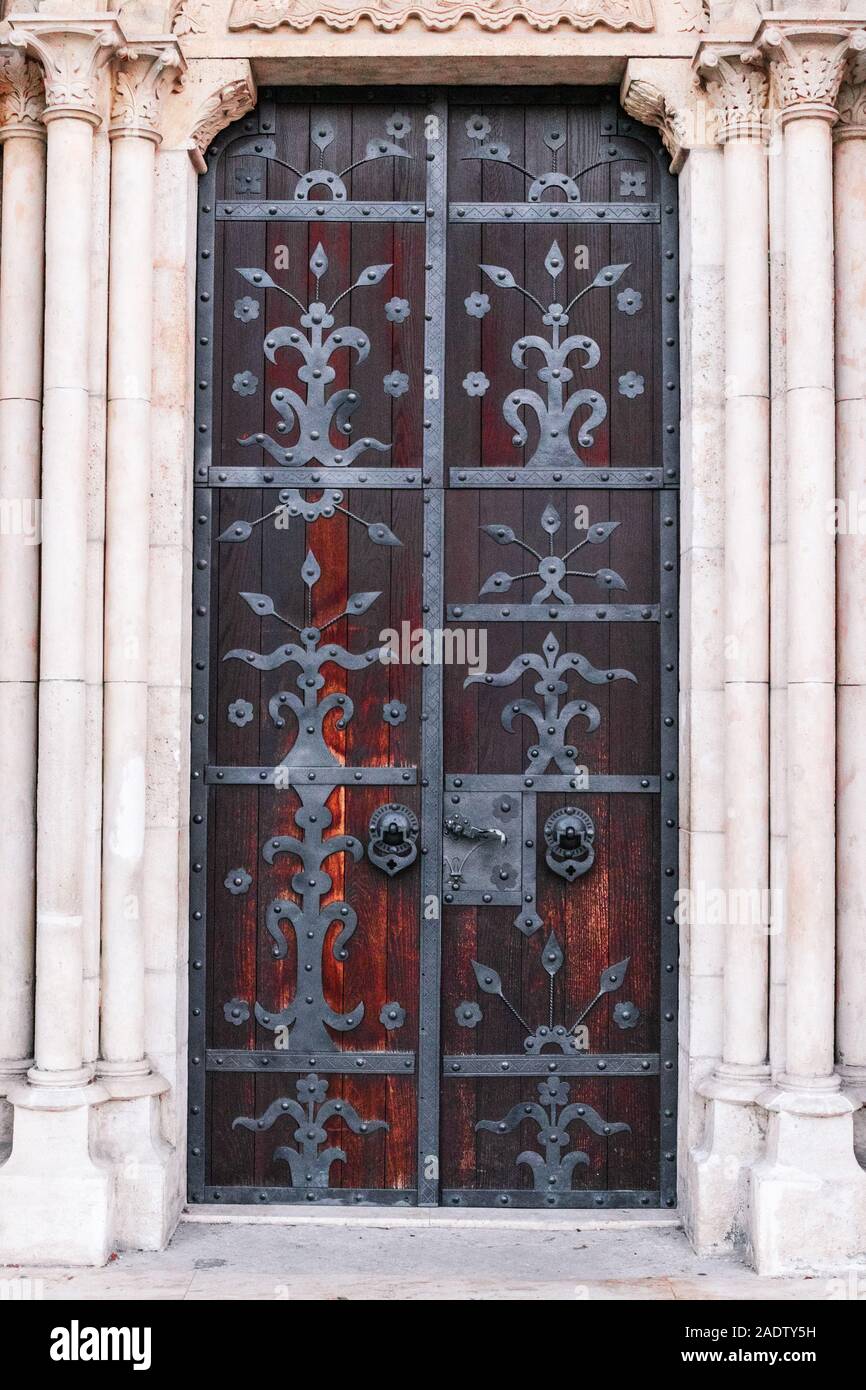 Closed ornate wooden door with barred iron window and iron bars. Metal ...
