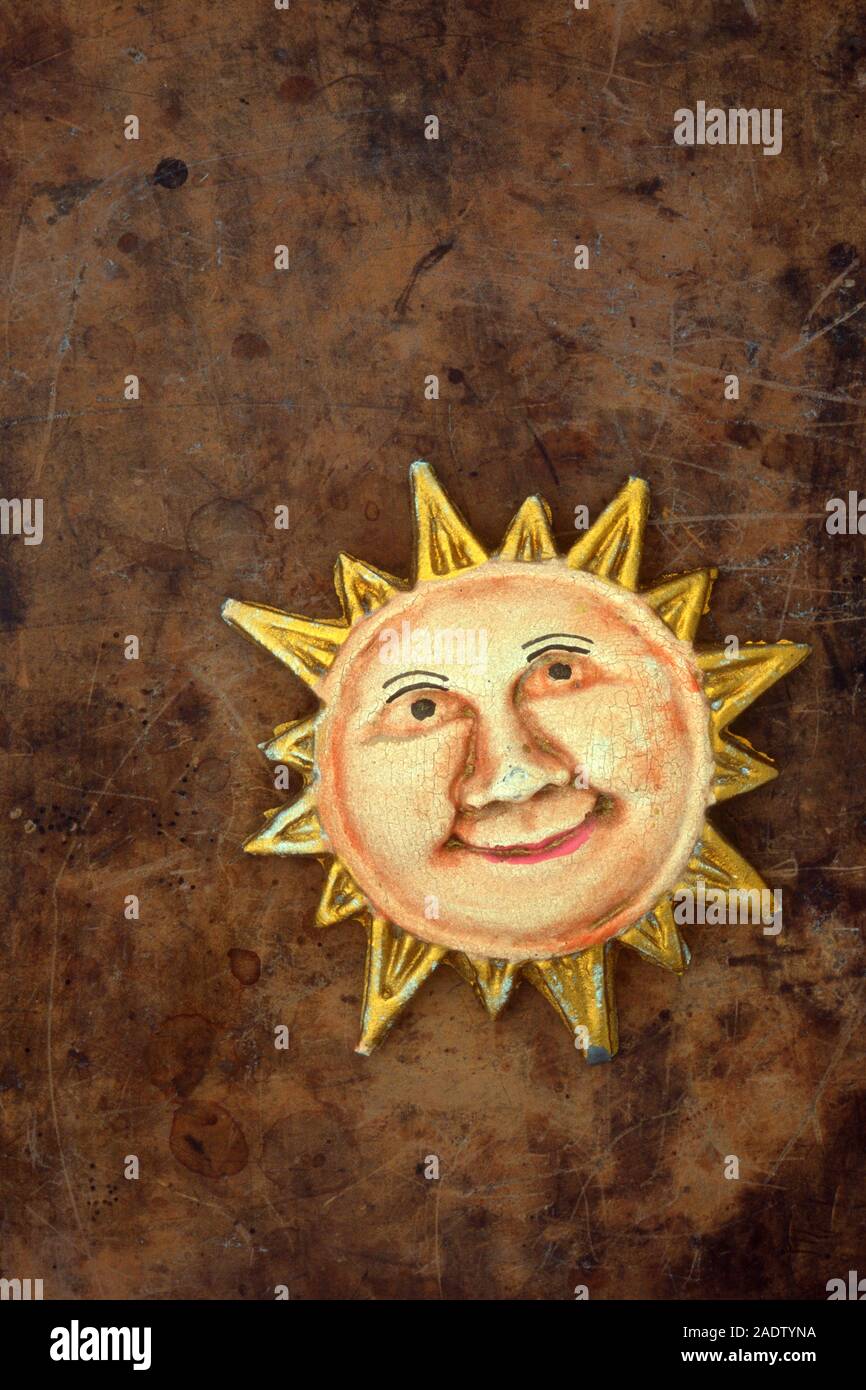 Plaster model of sun with smiley face and projecting flames or rays ...
