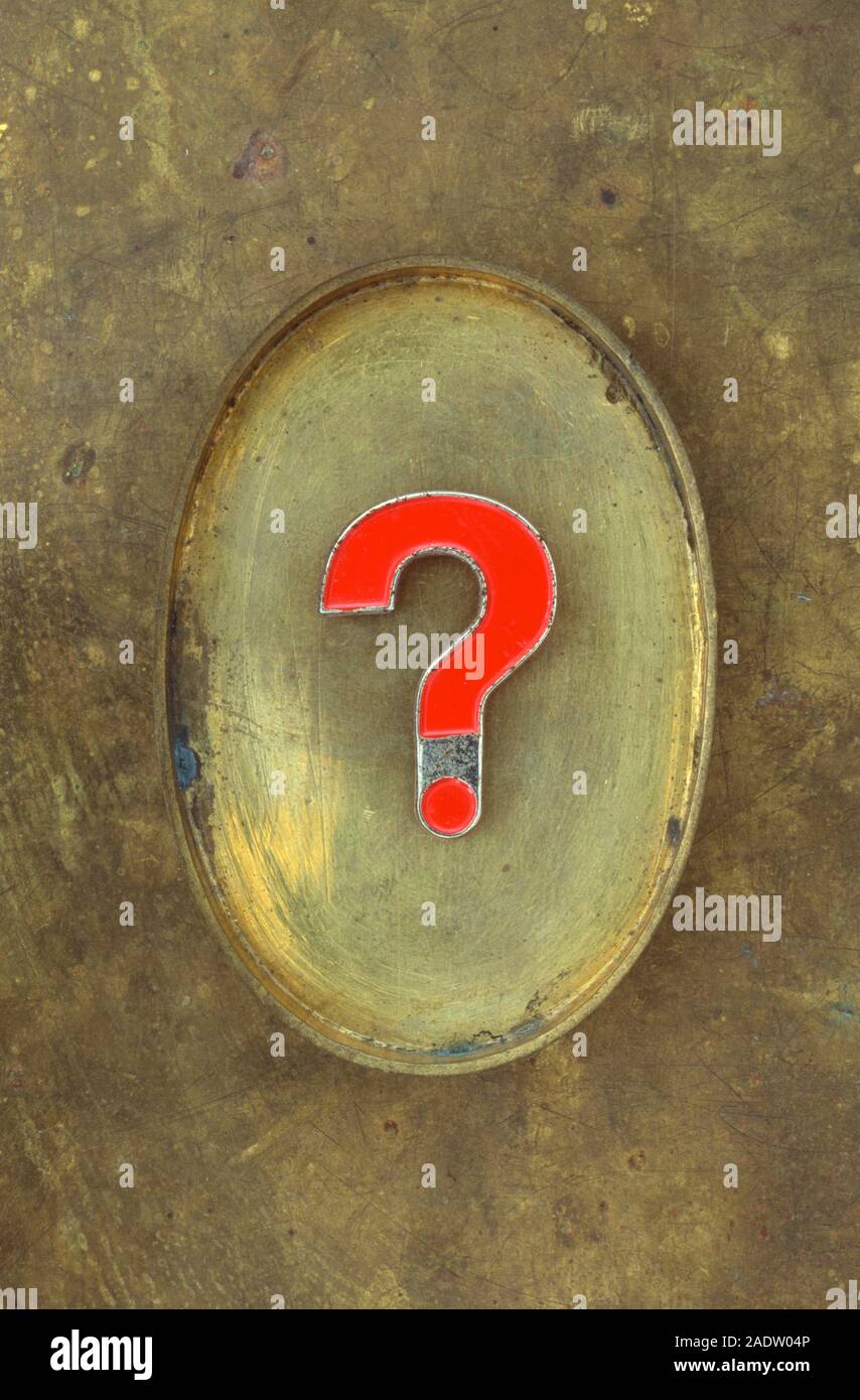 Brass oval containing red metal question mark Stock Photo - Alamy