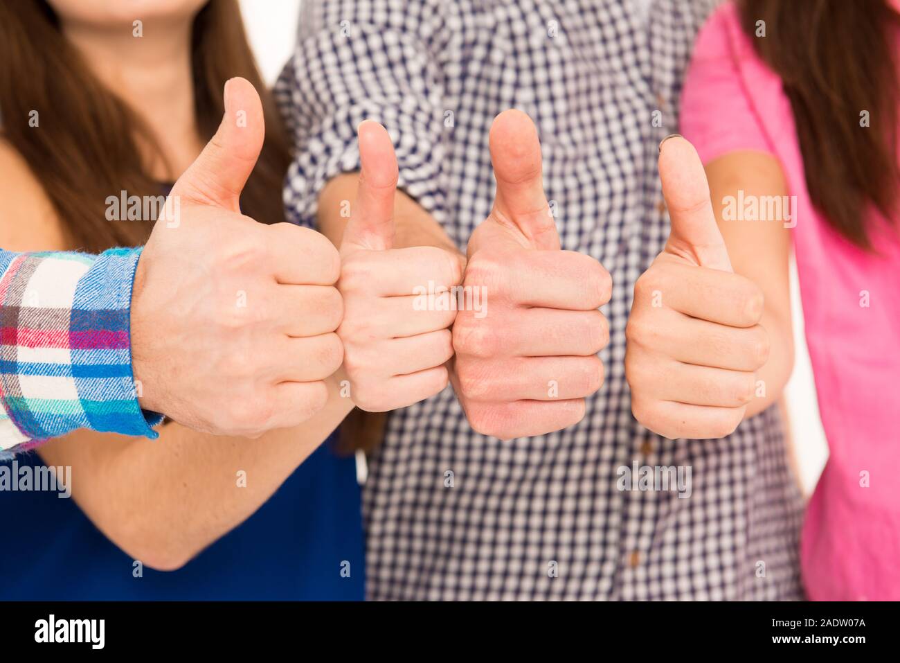Closeup photo of a young group showing thumbs up Stock Photo - Alamy
