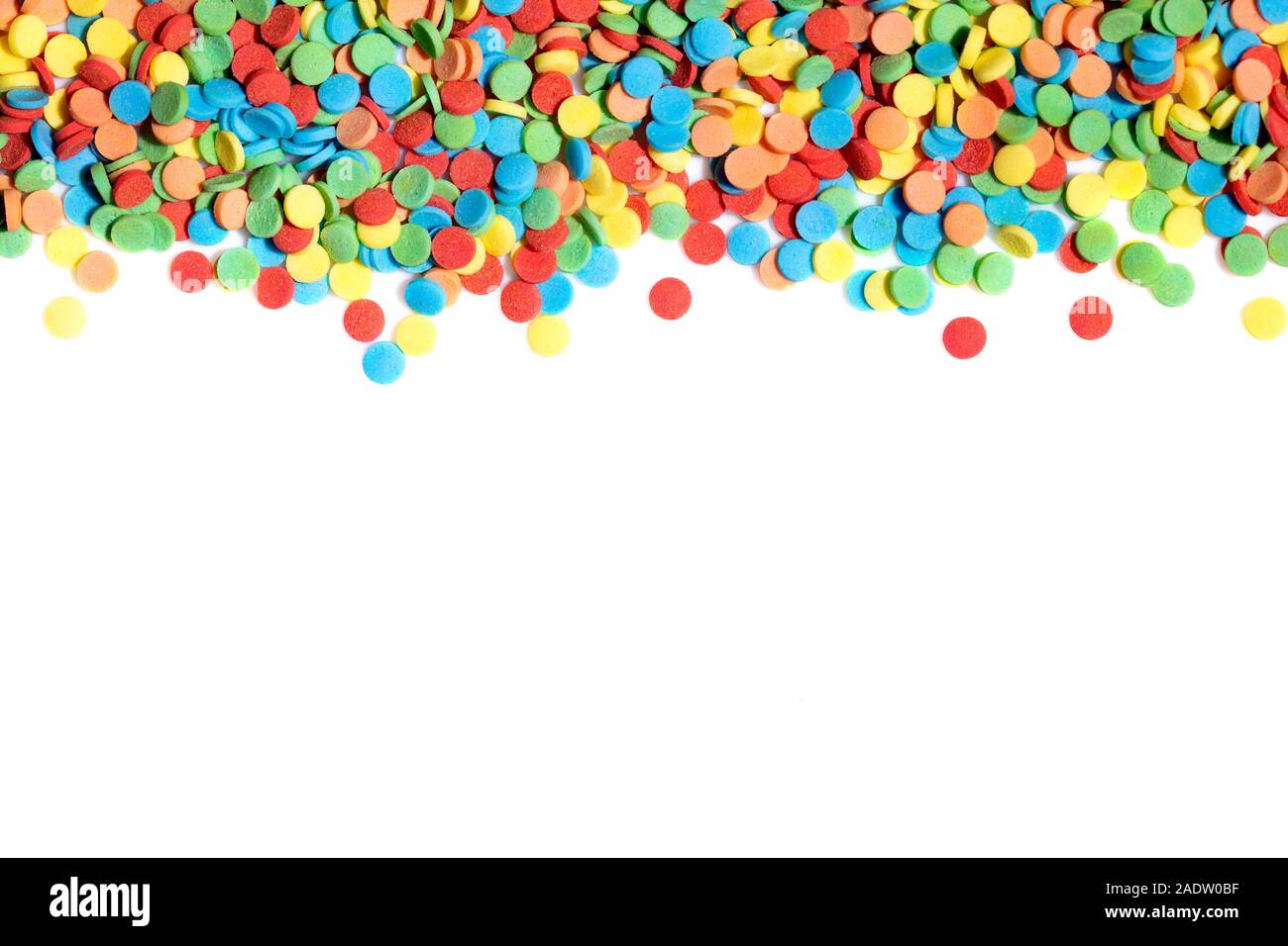 colorful round sprinkles or sugar confetti on white background with ...