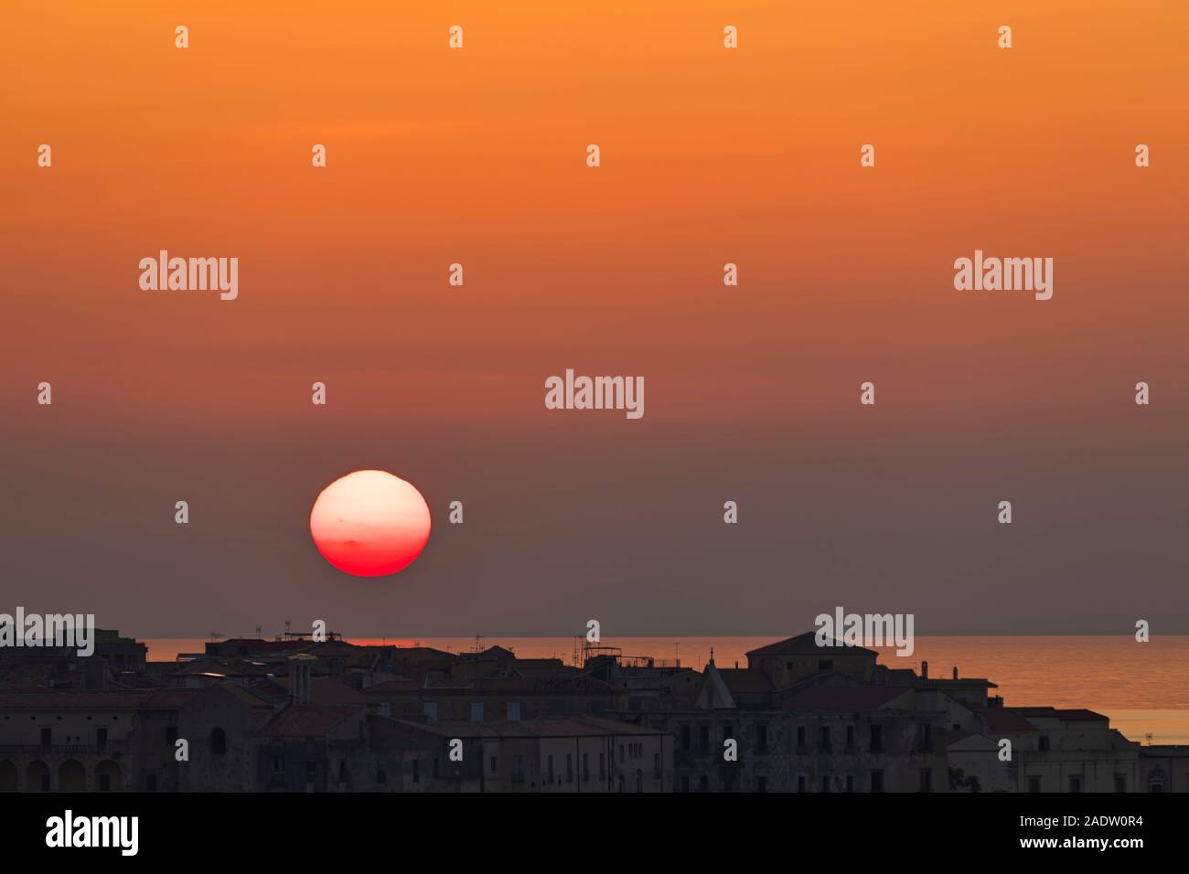 sunset with big red sun just above horizon at Tropea horizontal Stock ...