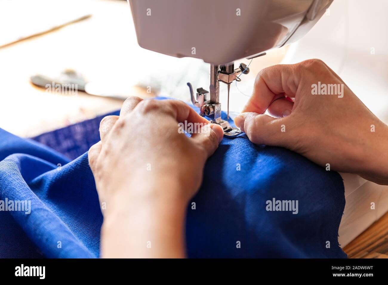 closeup of a woman, trying to thread a needle of a sewing machine Stock ...