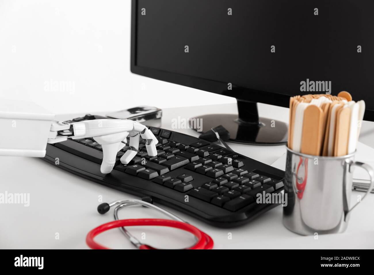 closeup of an ai robotic hand, using a keyboard in a medical office or ...