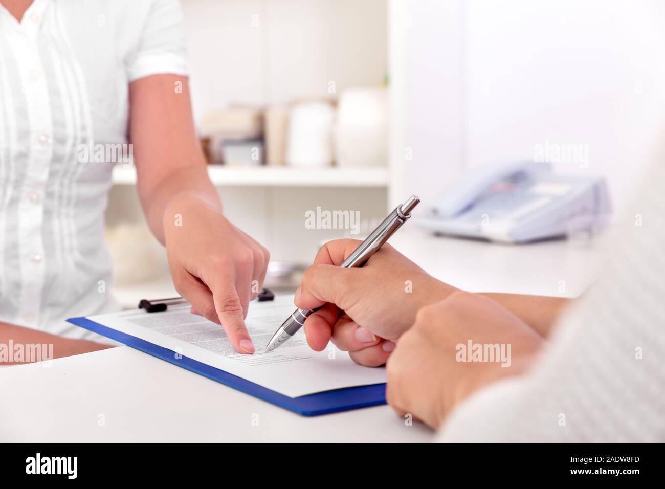 female patient is signing some documents in an medical office Stock ...