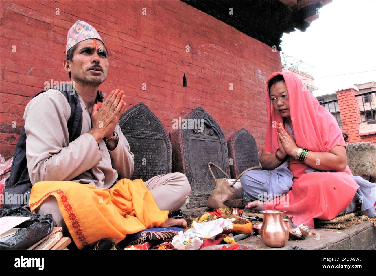 TWO PEOPLE SITTING ON THE GROUND IN A MOMENT OF PRAYER Stock Photo - Alamy