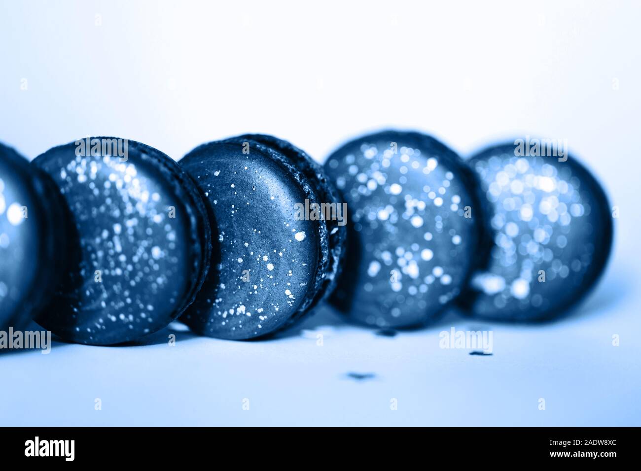 Dark blue macarons in a row with space pattern on white background ...