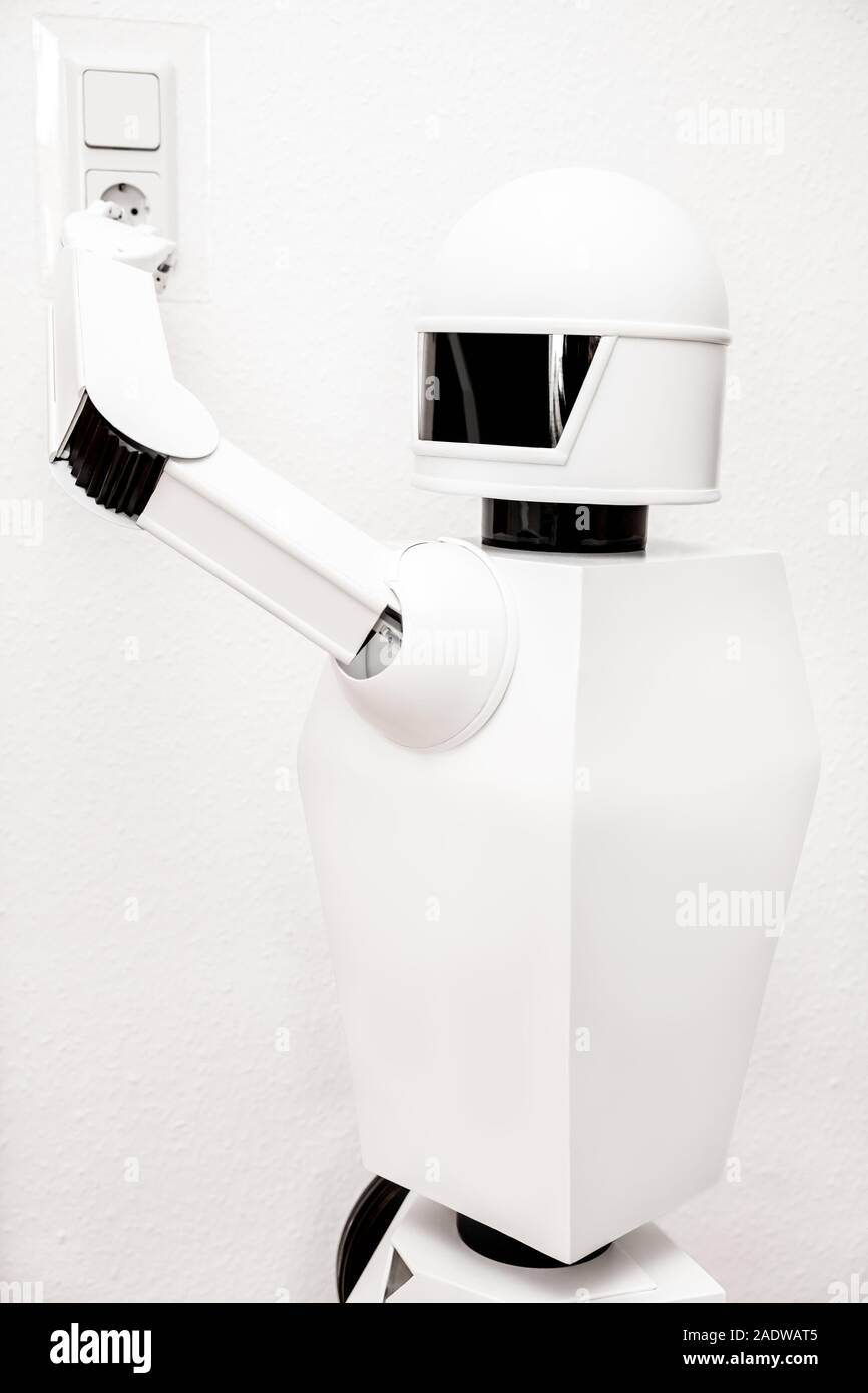 white robot is recharging himself on a german socket, holding his ...