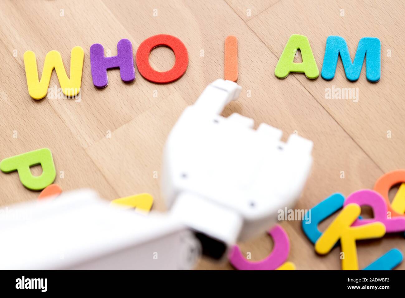 robot arm is pointing with his finger to colorful letters, building the ...