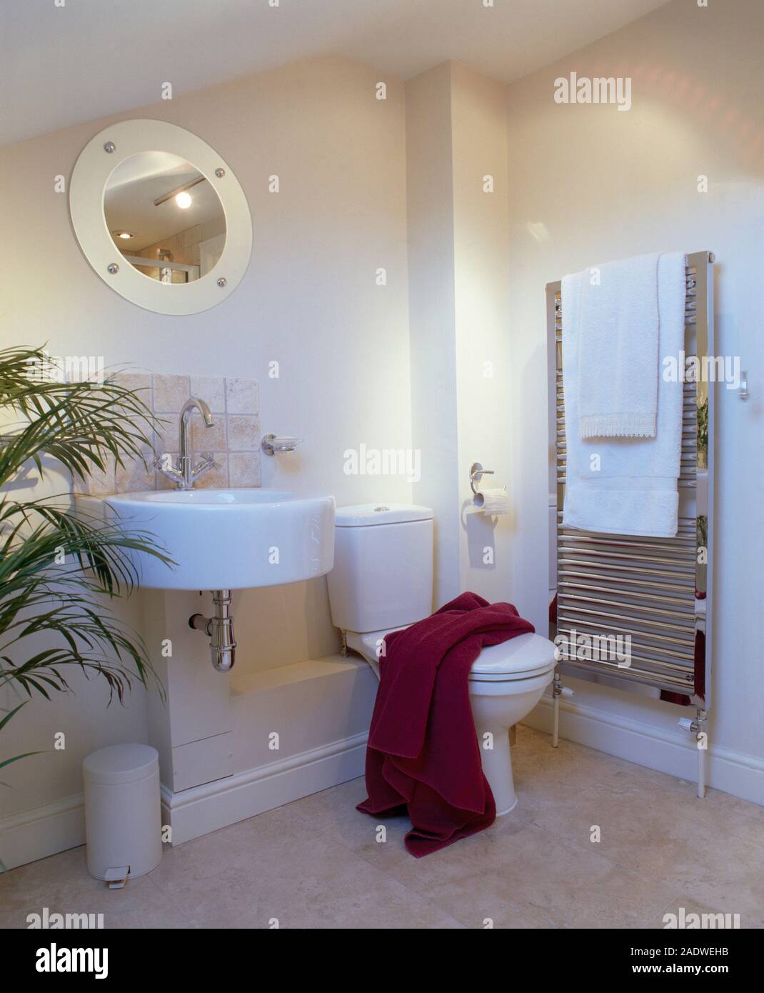 Circular mirror above basin in a modern bathroom with a stainless steel ...