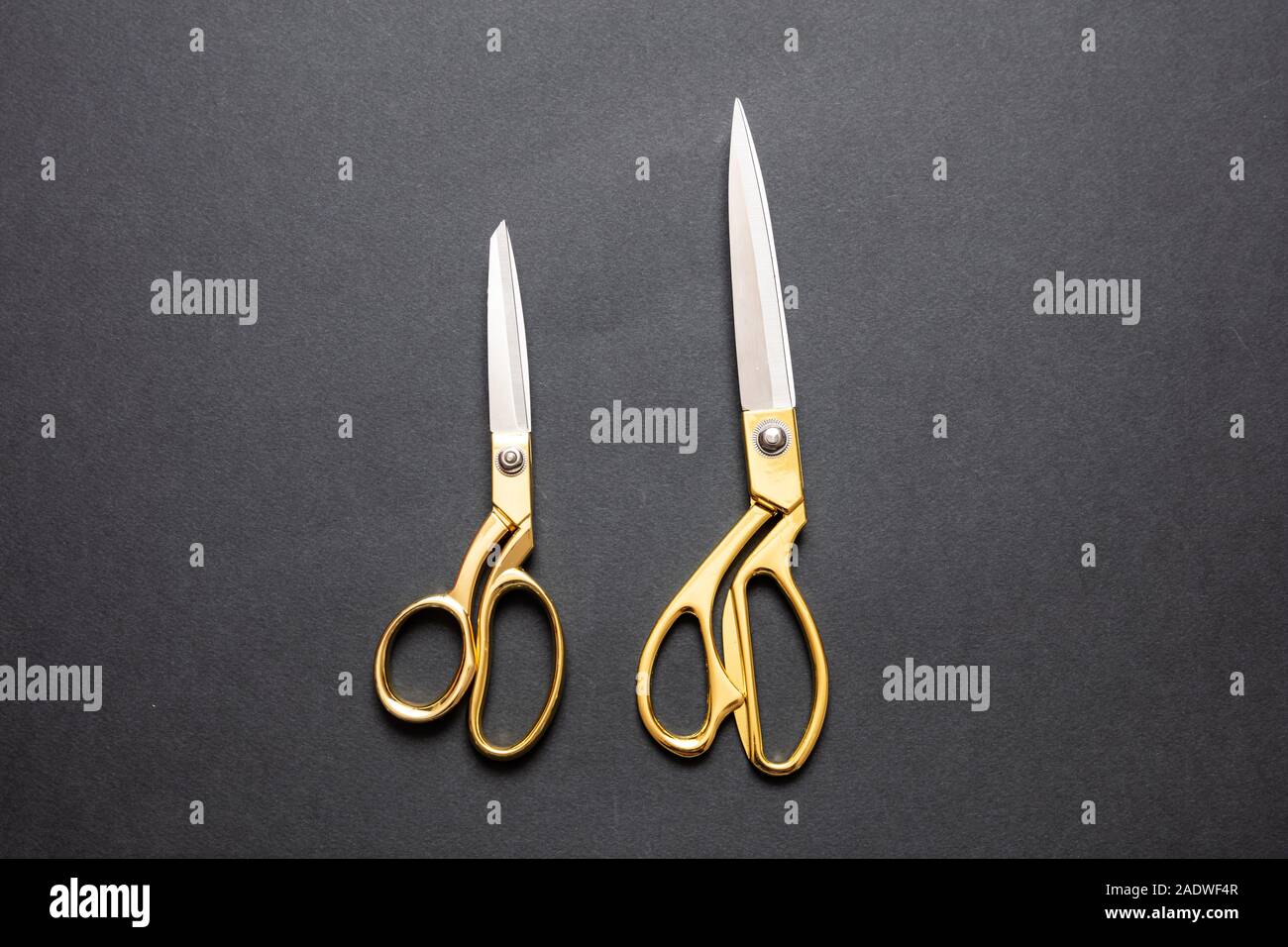 Two pairs of scissors gold silver color isolated on black background ...