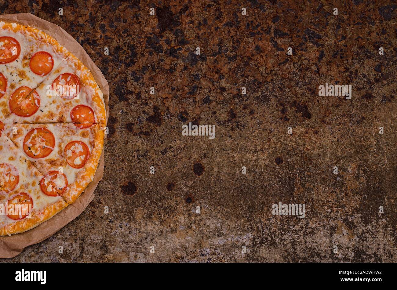 Pizza with cheese and tomatoes with copy space on an unusual brutal ...