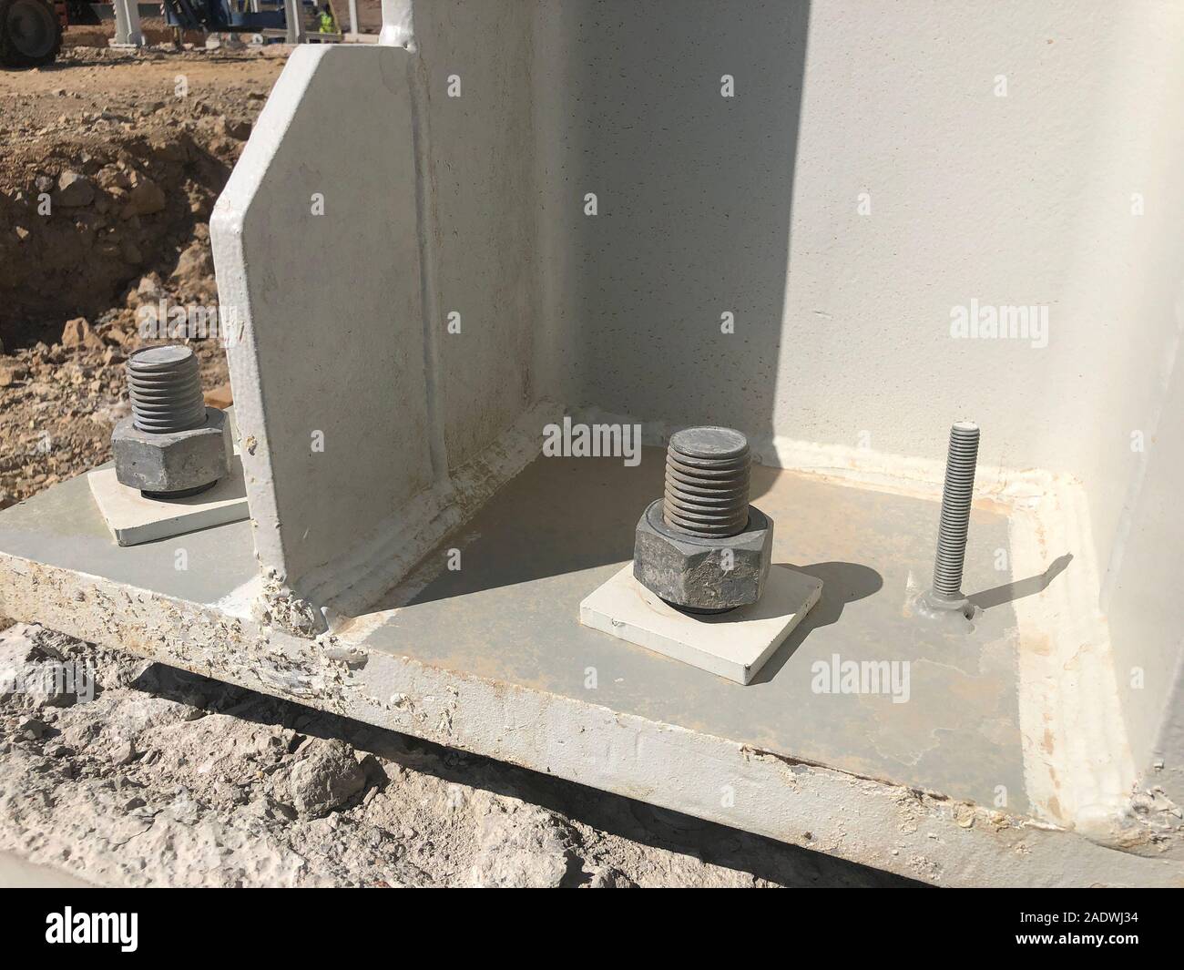 Metal pillar fastened to basement with anchor bolts and nuts ...