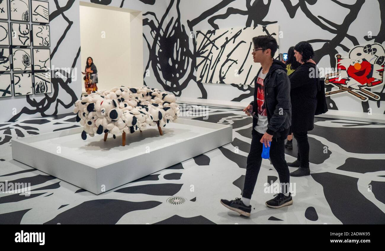 People standing by art by Brian Donnelly aka KAWS sculptor and graffiti ...