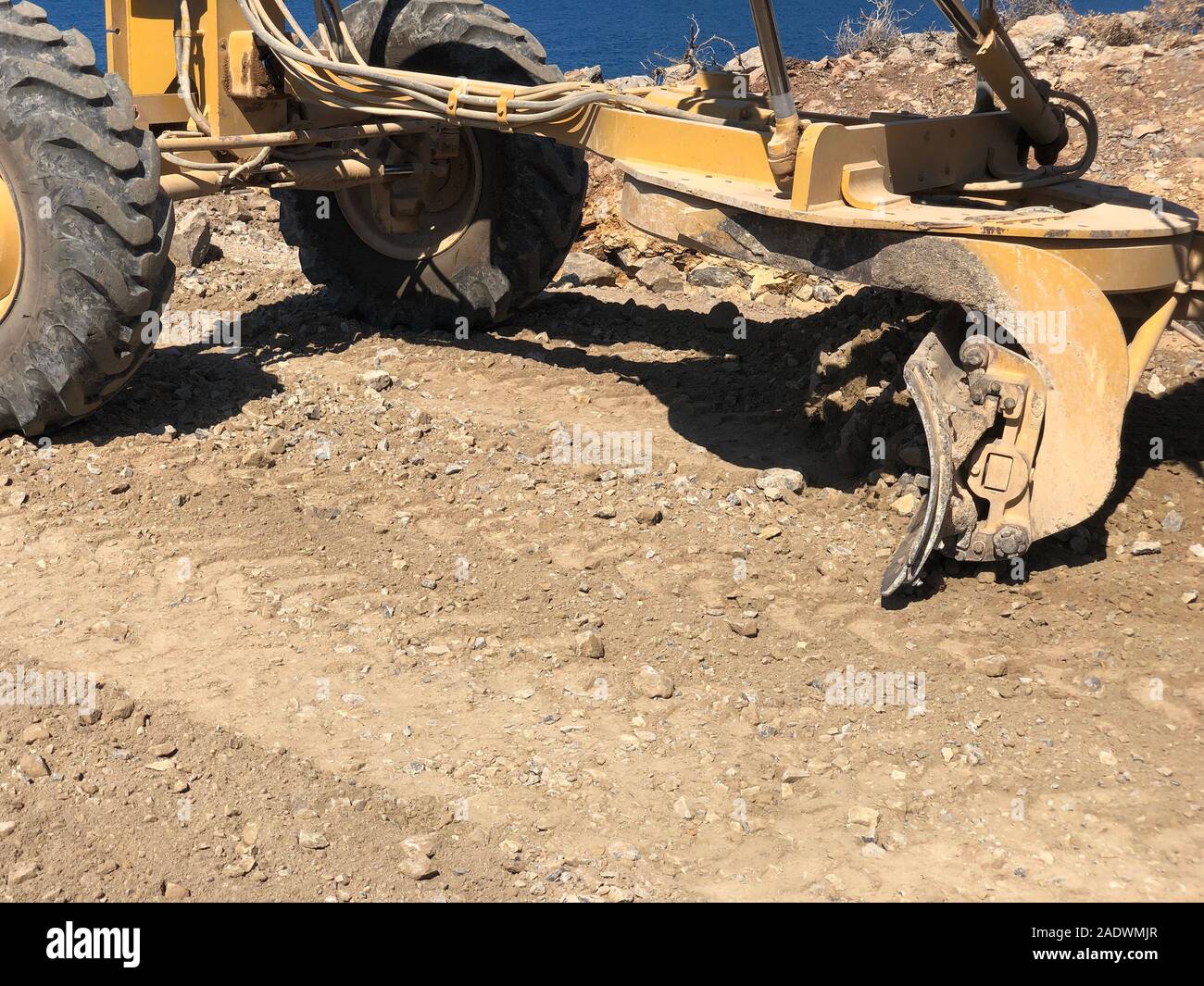 Close-up of moldboard planning road surface. Blade of motor grader ...