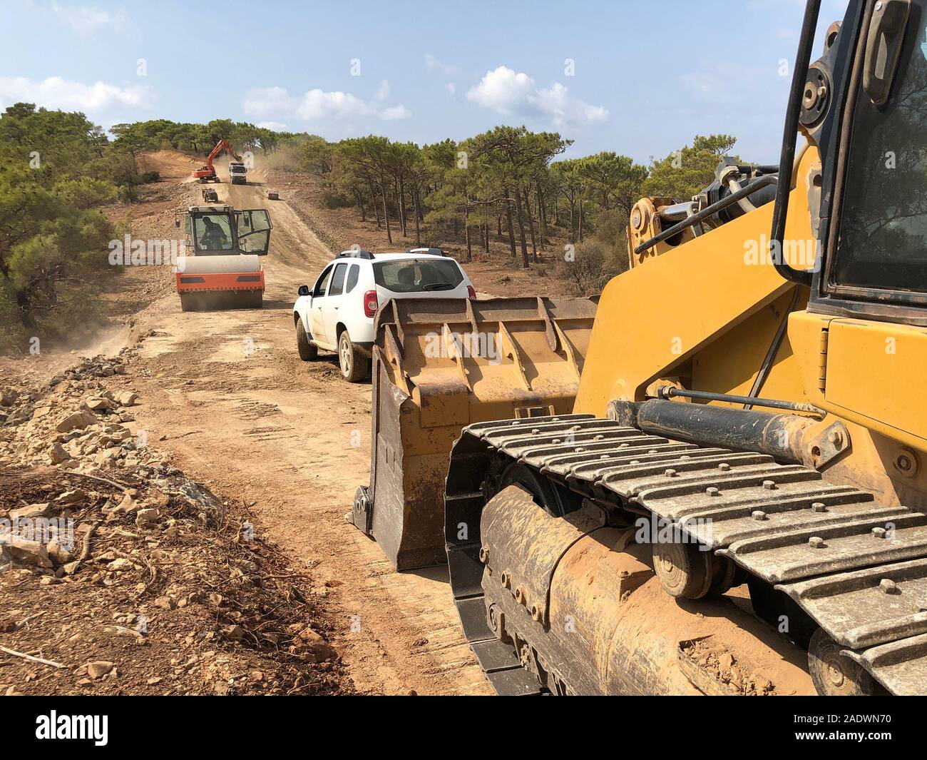 Earthworks of highland forest road. Different types of machinery on the ...