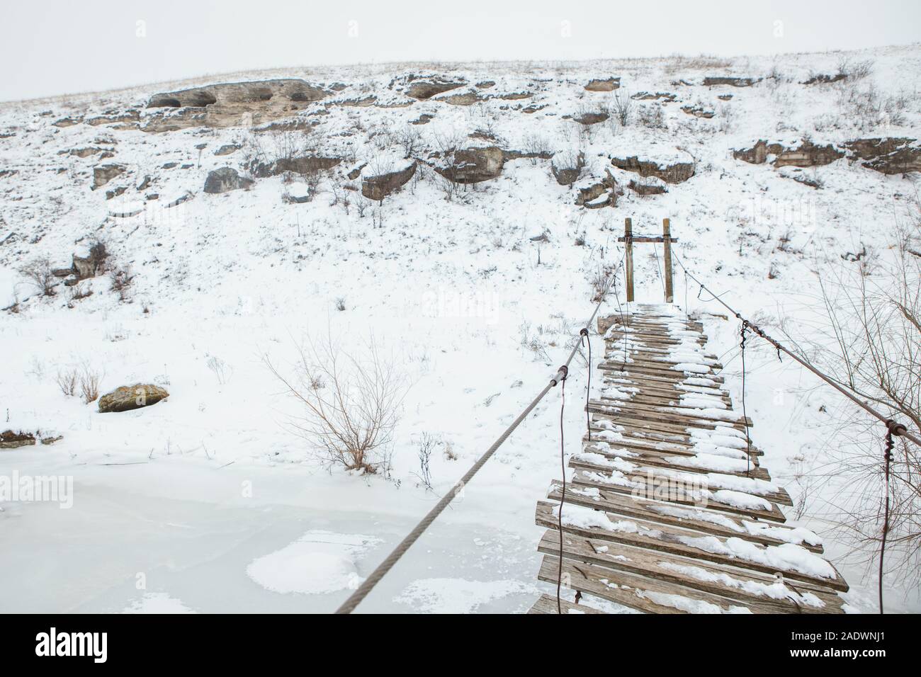 pedestrian old hanging bridge over the frozen river Stock Photo - Alamy