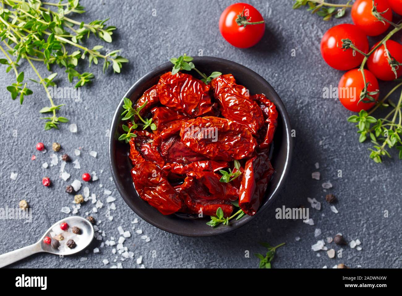 Sun dried tomatoes with fresh herbs and spices. Slate background. Top ...
