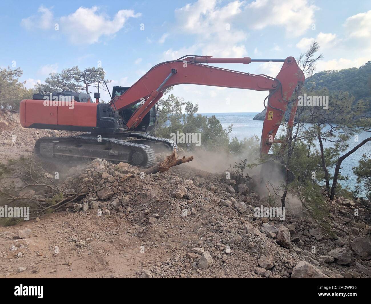 Excavator moving soil with lots of dust during excavation works on the ...