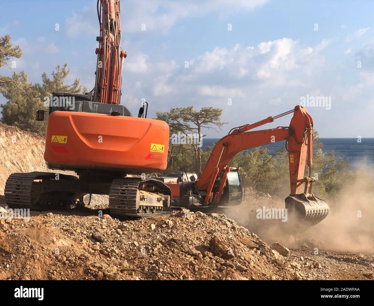 Excavator moving soil with lots of dust during excavation works on the ...