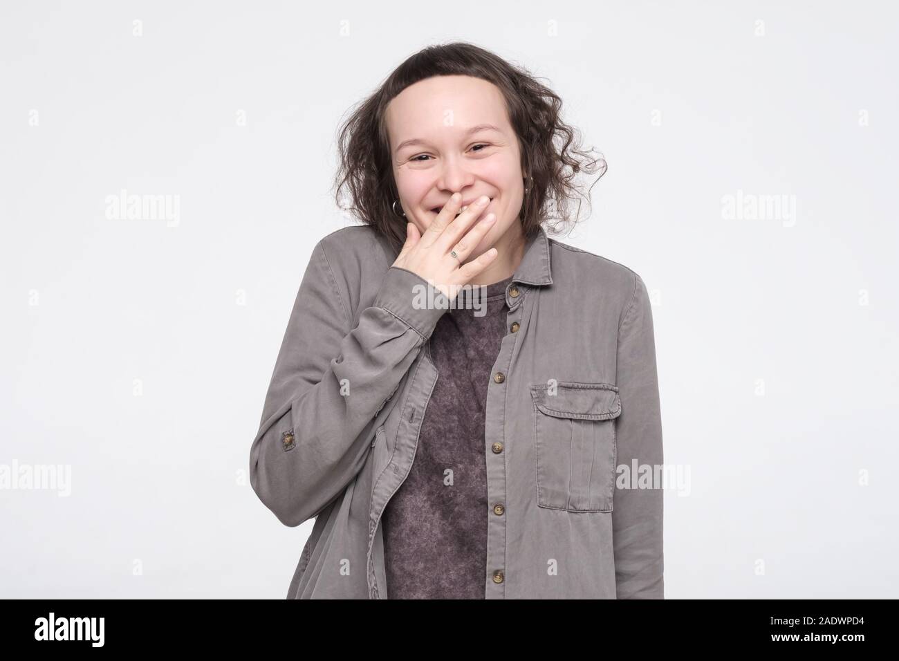Pretty caucasian young woman being shy laughing covering her mouth with ...