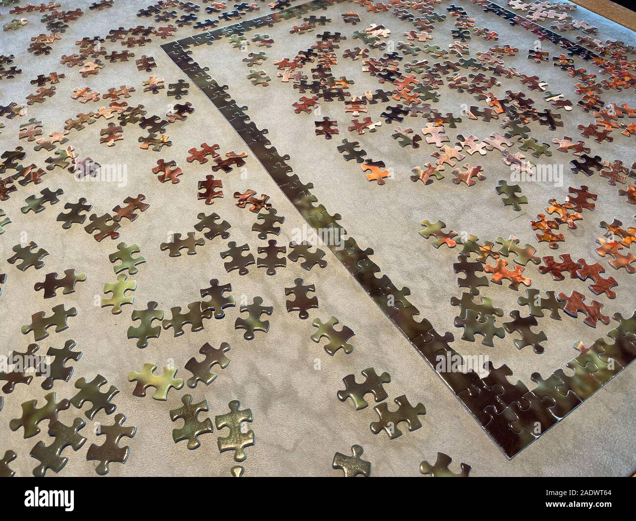 A colorful puzzle with the edges completed on a leather looking table ...