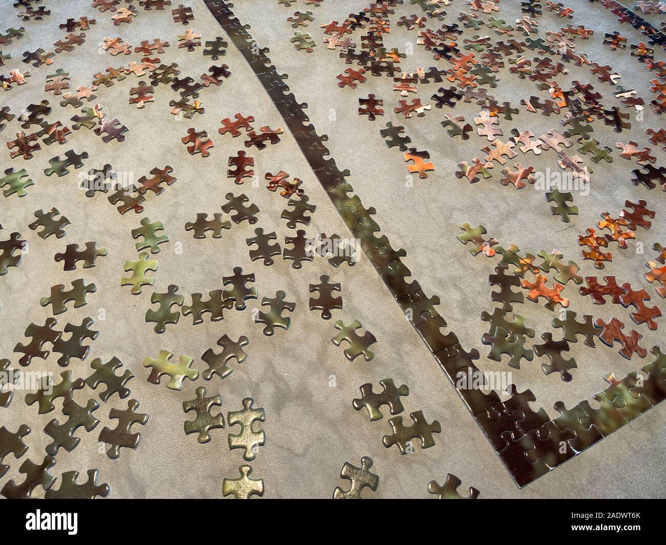 A colorful puzzle with the edges completed on a leather looking table ...