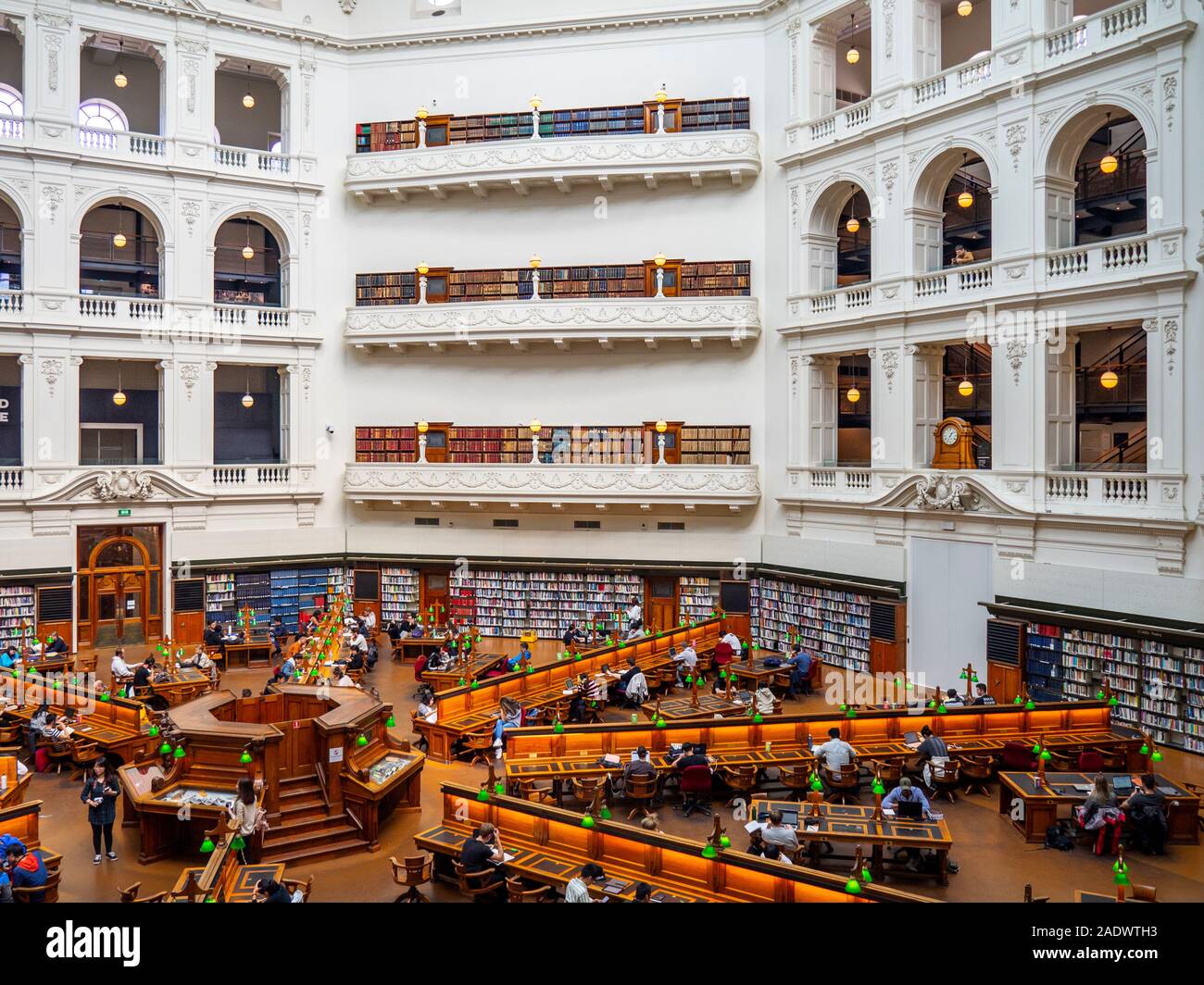 Wooden tables full of students studying in the La Trobe Reading Room of ...