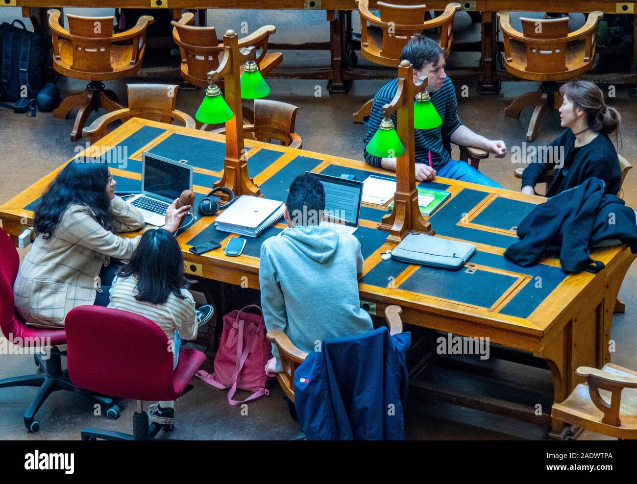 Wooden tables full of students studying in the La Trobe Reading Room of ...