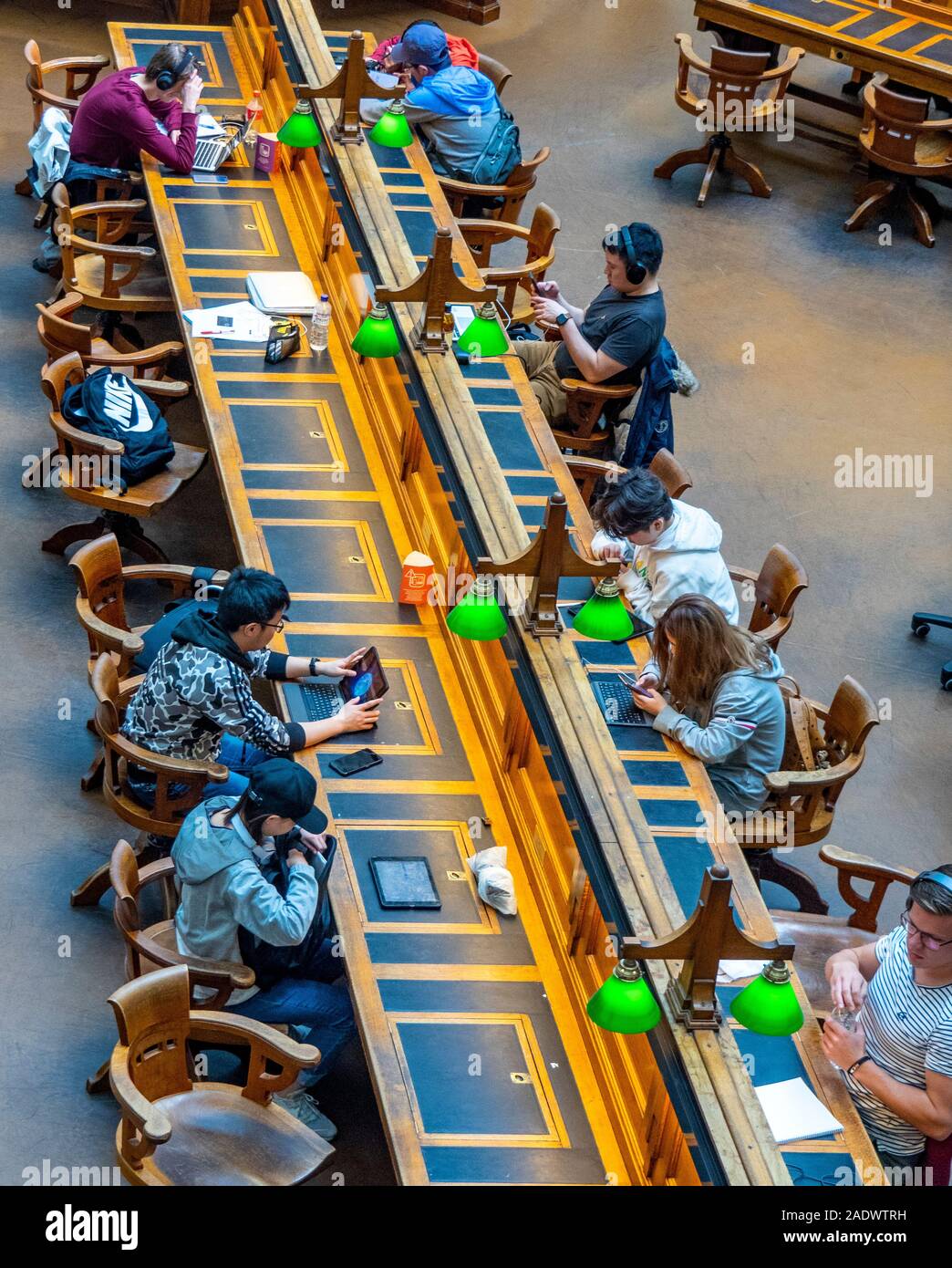 Wooden tables full of students studying in the La Trobe Reading Room of ...