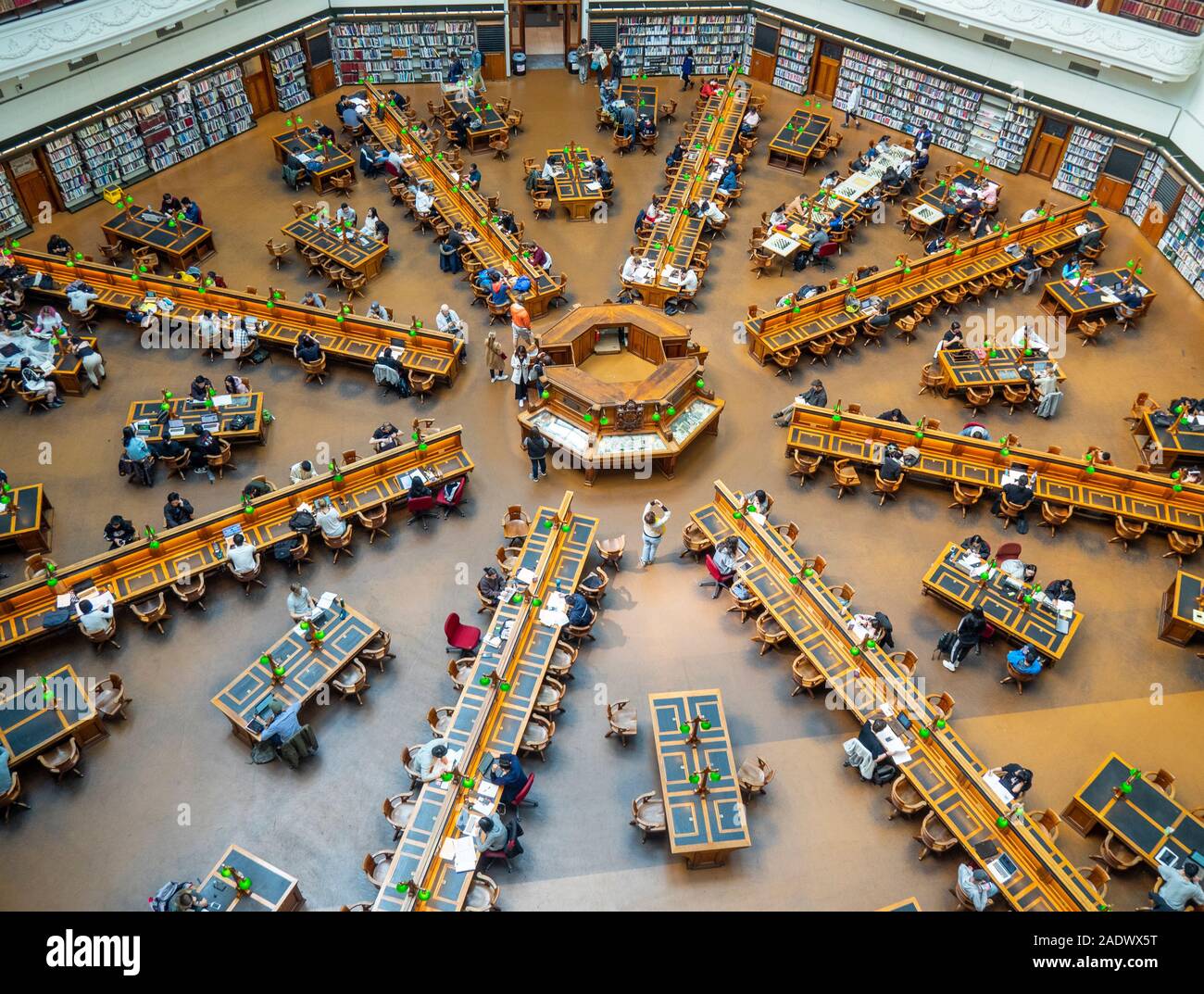 Wooden tables full of students studying in the La Trobe Reading Room of ...