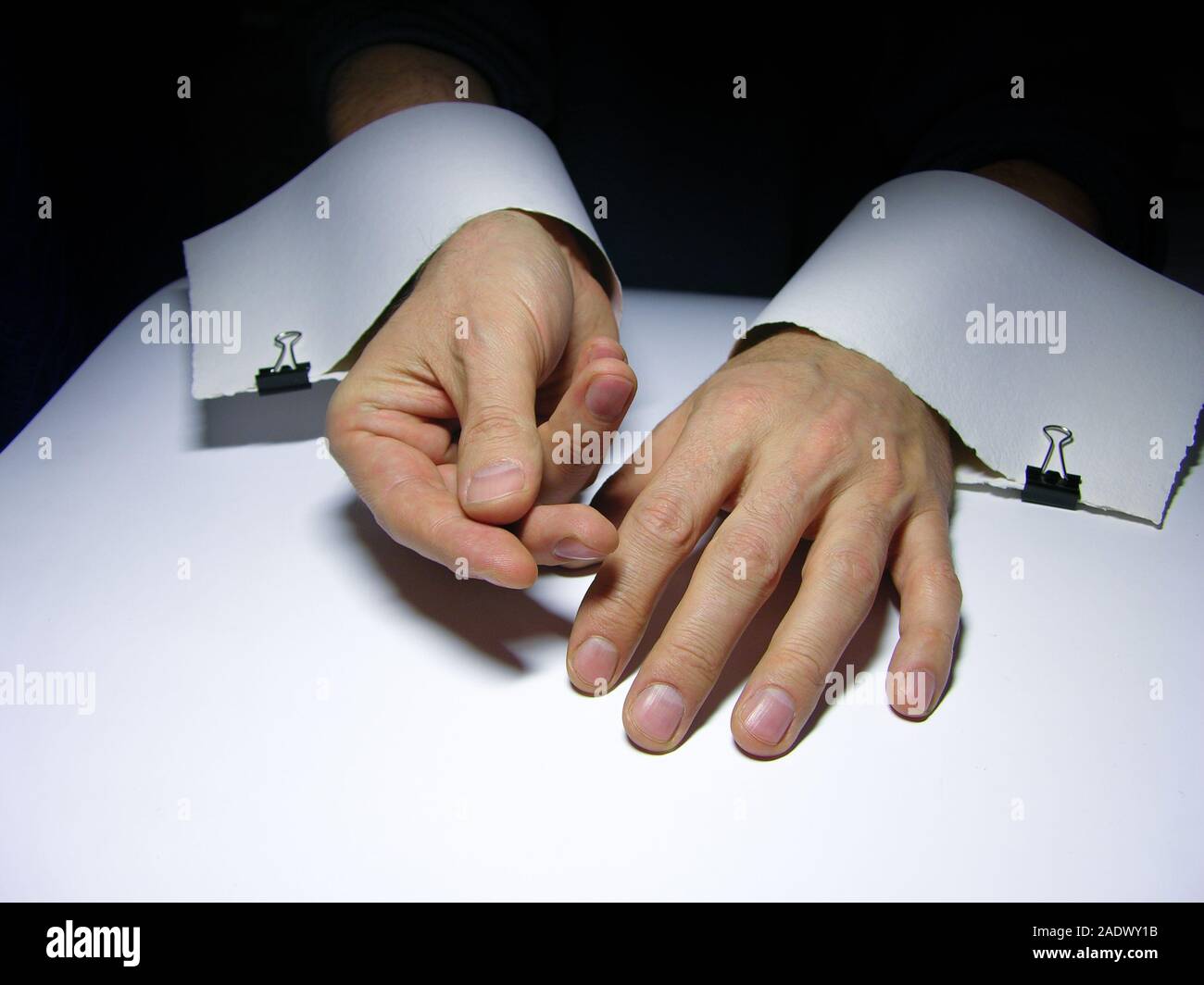 Man's hands in paper cuffs fastened with metal clips Stock Photo - Alamy