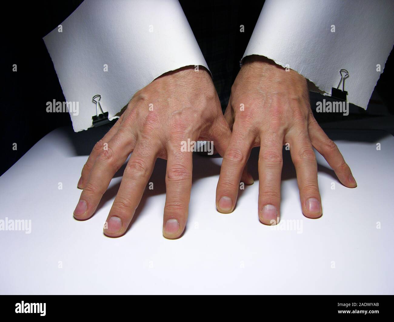 Man's hands in paper cuffs fastened with metal clips Stock Photo - Alamy