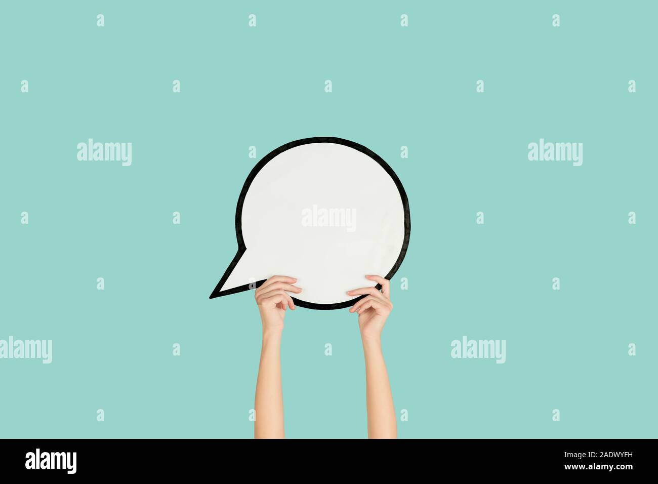 Hands holding the sign of comment on blue studio background. Negative ...