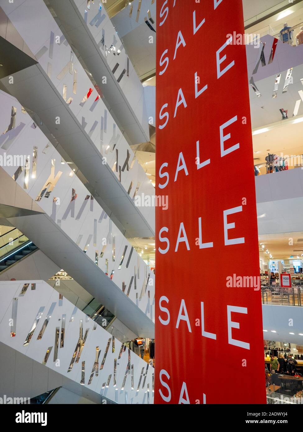 Large red sale banner Escalators connecting multiple levels in atrium ...