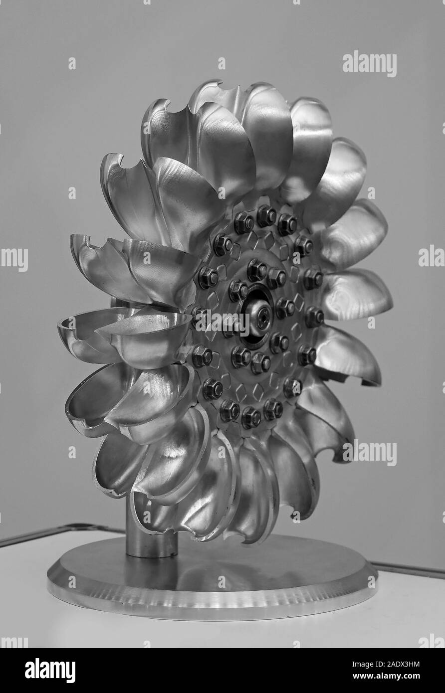 Central silver metal turbine machine part with gray wall background ...