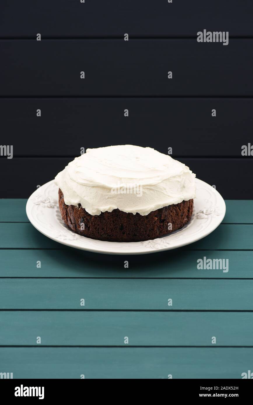 Minimalist style sweets. Chocolate fruit cake with cream cheese glasing ...