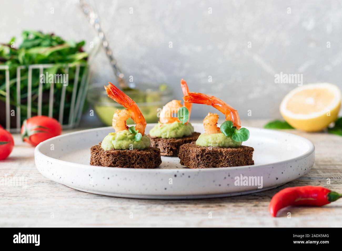 Canapes with avocado muslim and garlic shrimp on brown bread. Simple ...