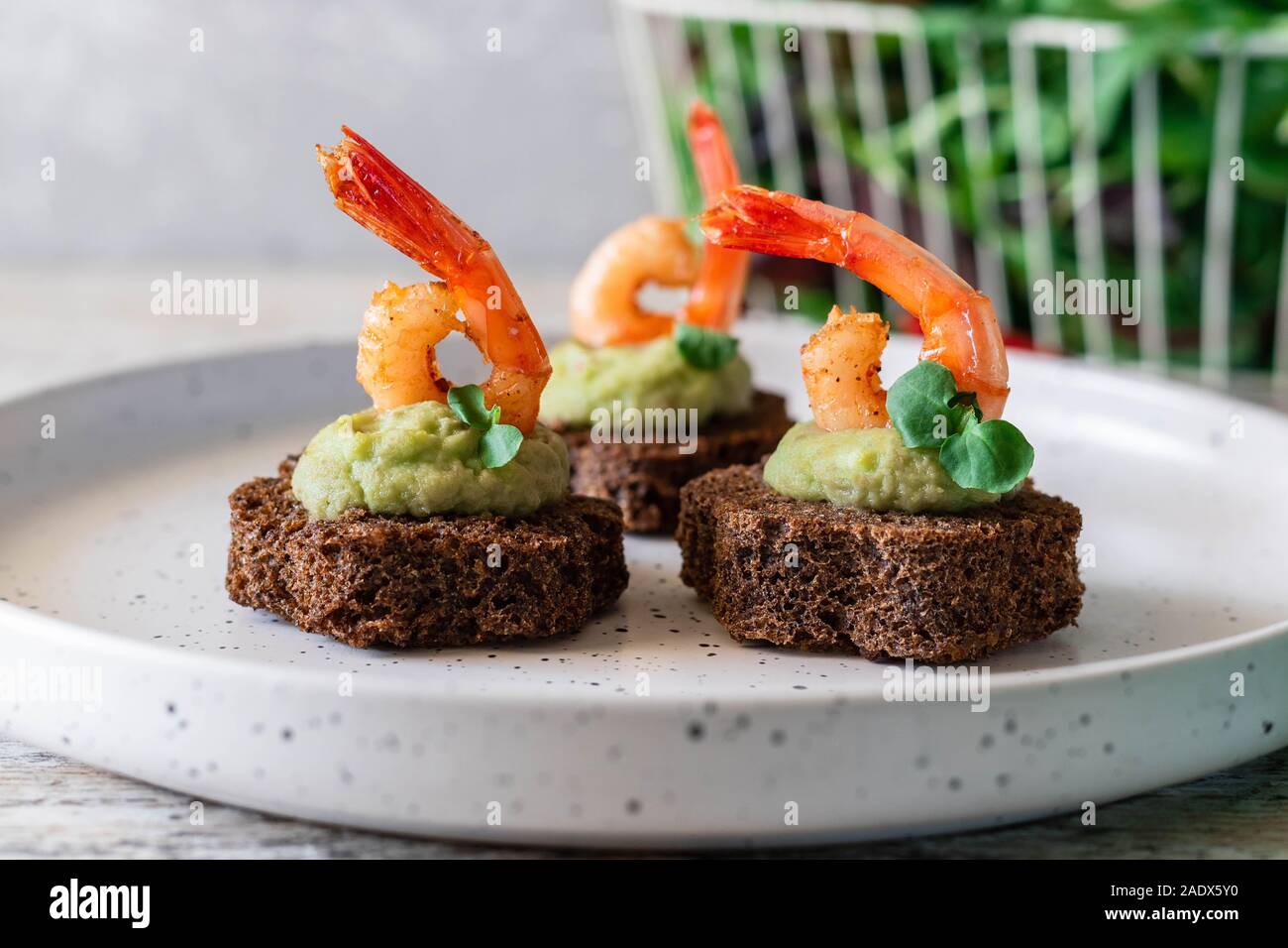 Canapes with avocado muslim and garlic shrimp on brown bread. Simple ...