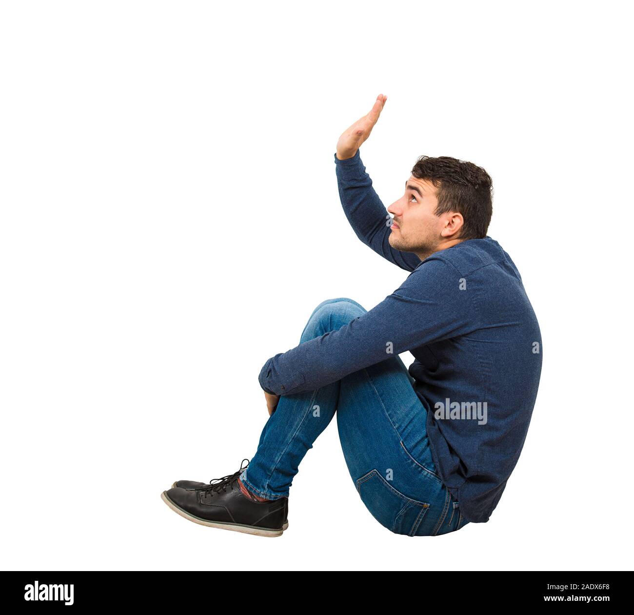 Side view scared young man introvert seated on the floor keeps hands ...