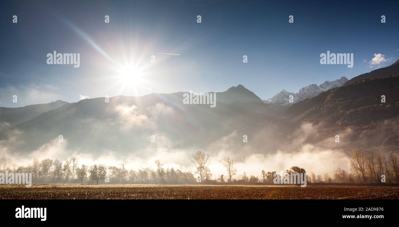mountain valley with fog and sun Stock Photo - Alamy