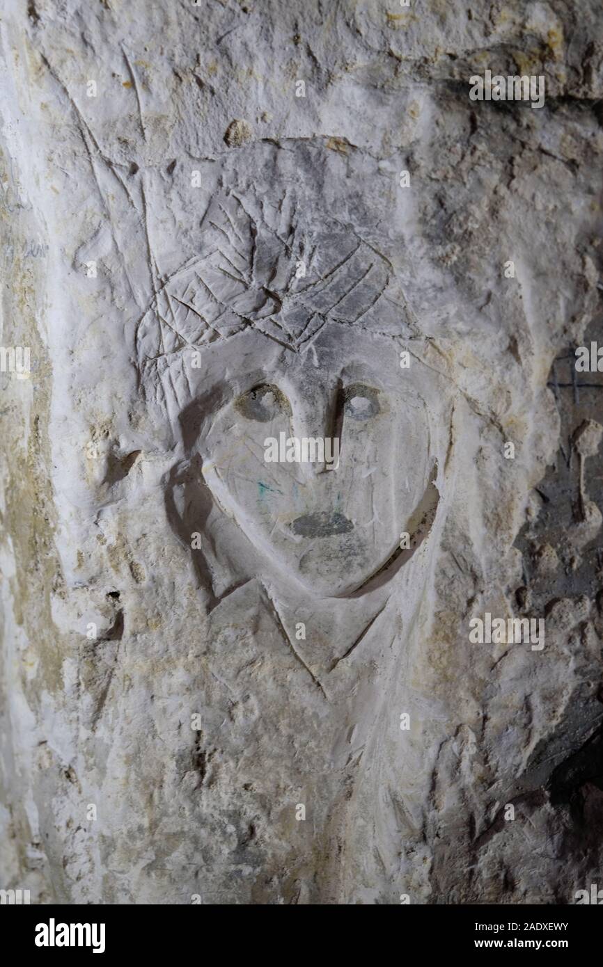 A face carved into the rock in the Cité souterraine de Naours ...