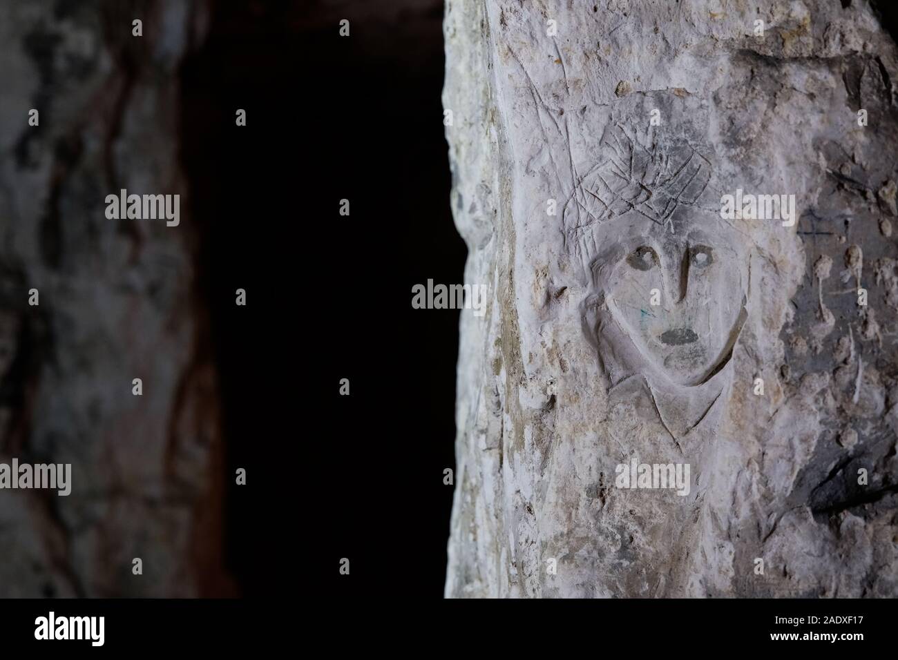 A face carved into the rock in the Cité souterraine de Naours ...