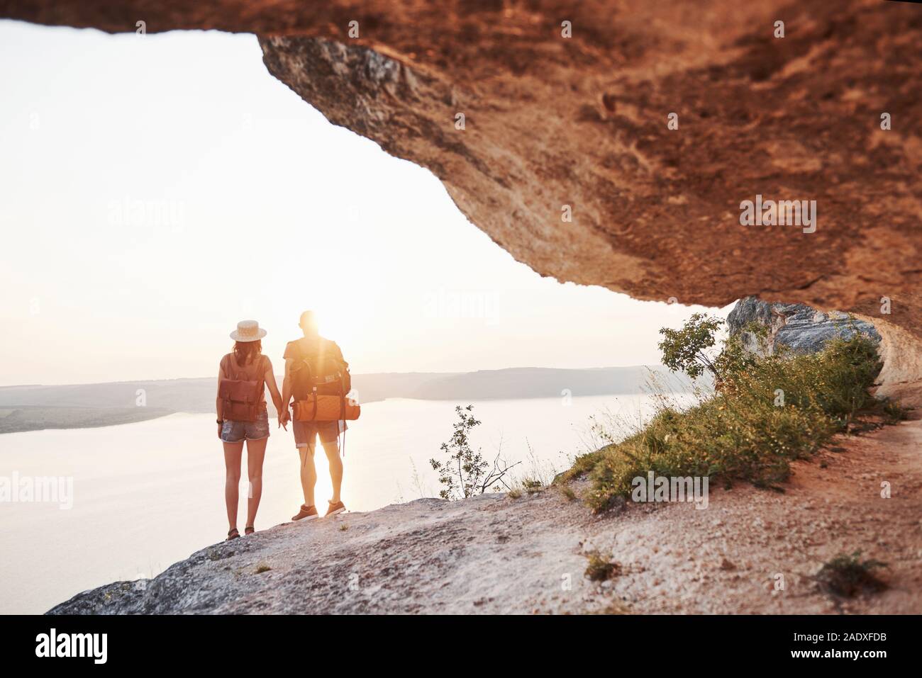 Two tourist male and woman with backpacks stand to the top of the ...