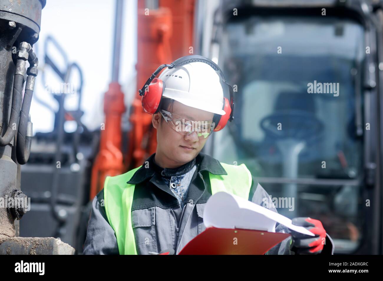 civil engineer standing in front of an excavator Stock Photo - Alamy