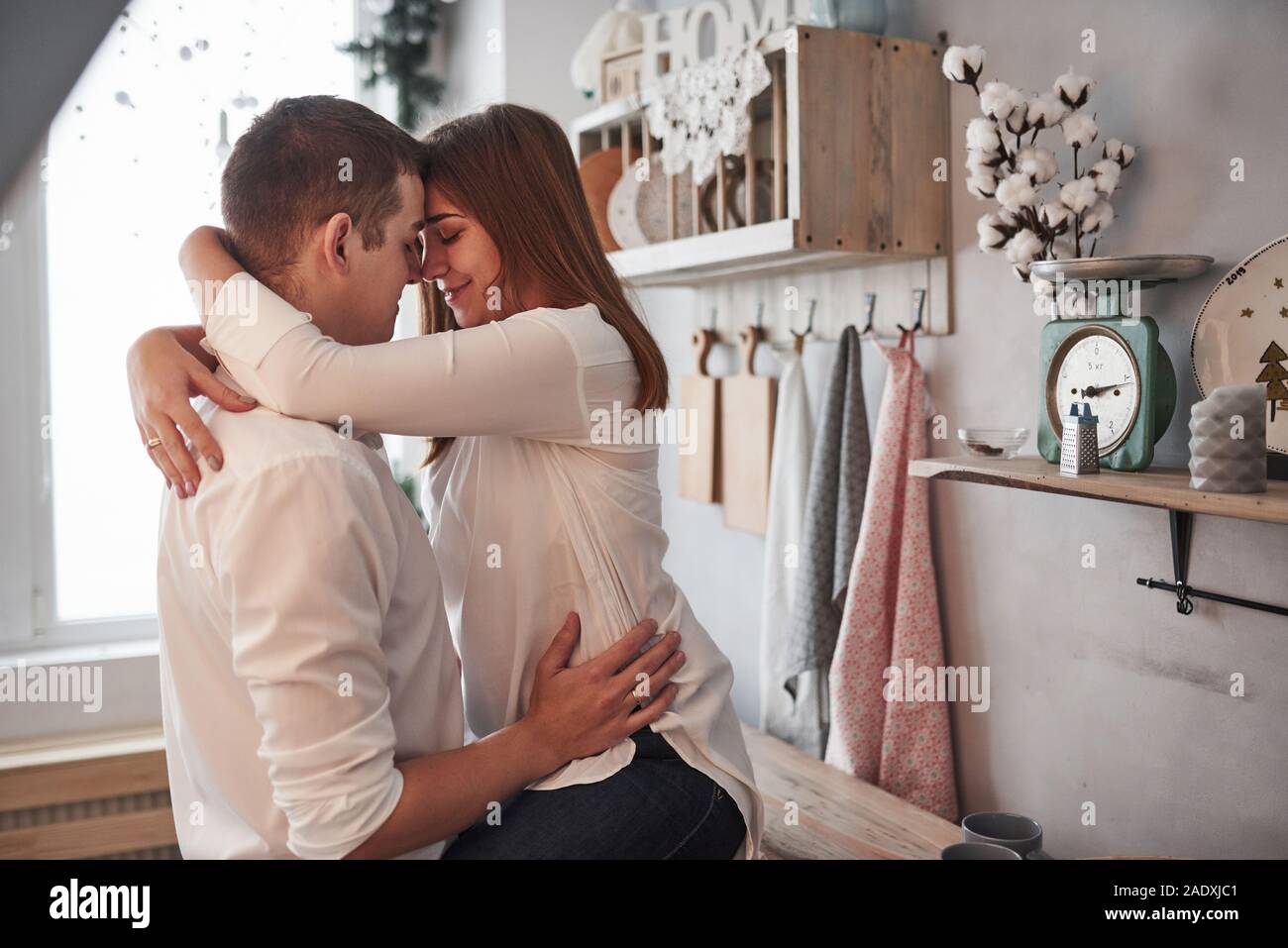 With eyes closed. Happy couple kissing in the kitchen. Having nice ...
