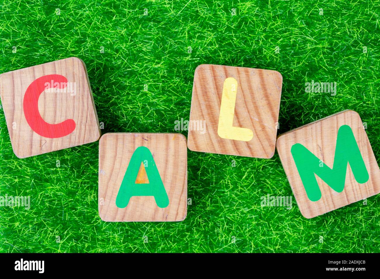 Word CALM written in wooden letters laid on grass . Concept of wellness ...